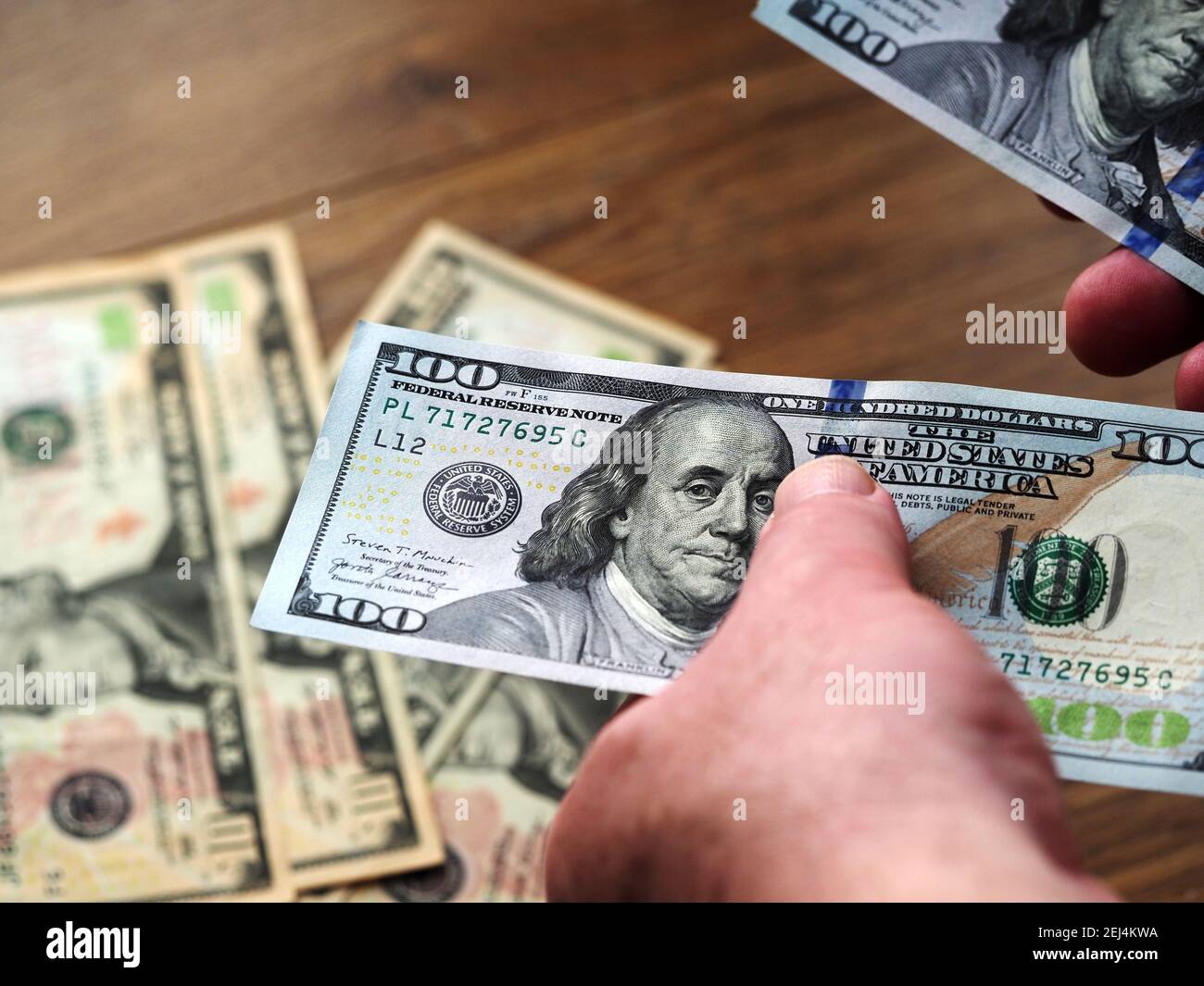 In this photo illustration, hands are seen counting US 100 dollar bills ...