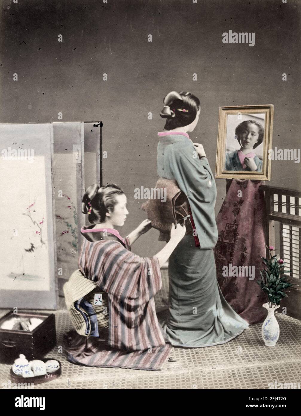 Late 19th century vintage photograph: Geisha having her obi sash tied ...