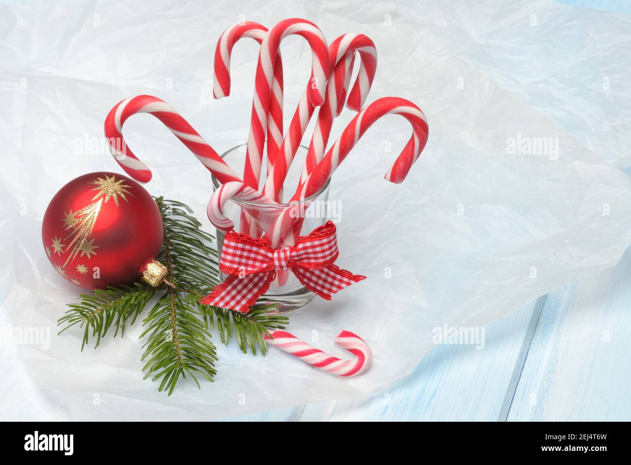 Candy canes in glass and Christmas tree ball with fir branch, red-white ...