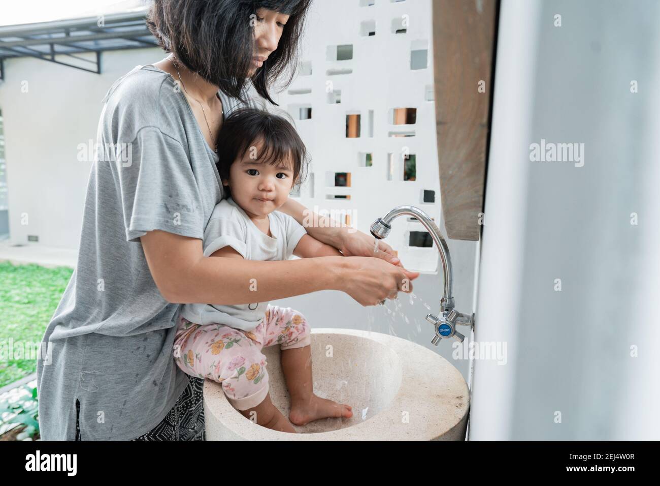 Cute little Asian toddler baby child washing cleaning hands with mom on ...