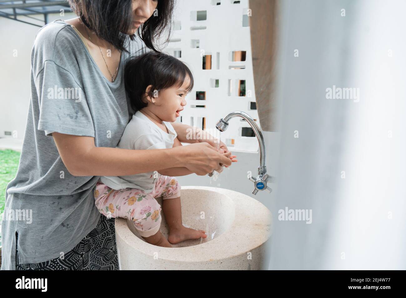 Cute little Asian toddler baby child washing cleaning hands with mom on ...