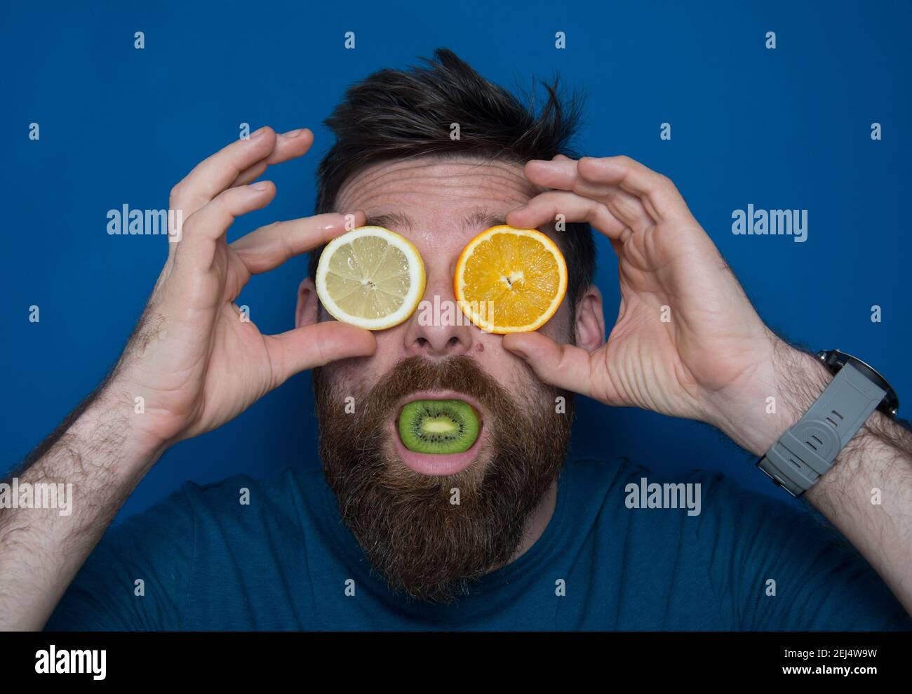 Man poses with kiwi and lemons on his face Stock Photo - Alamy