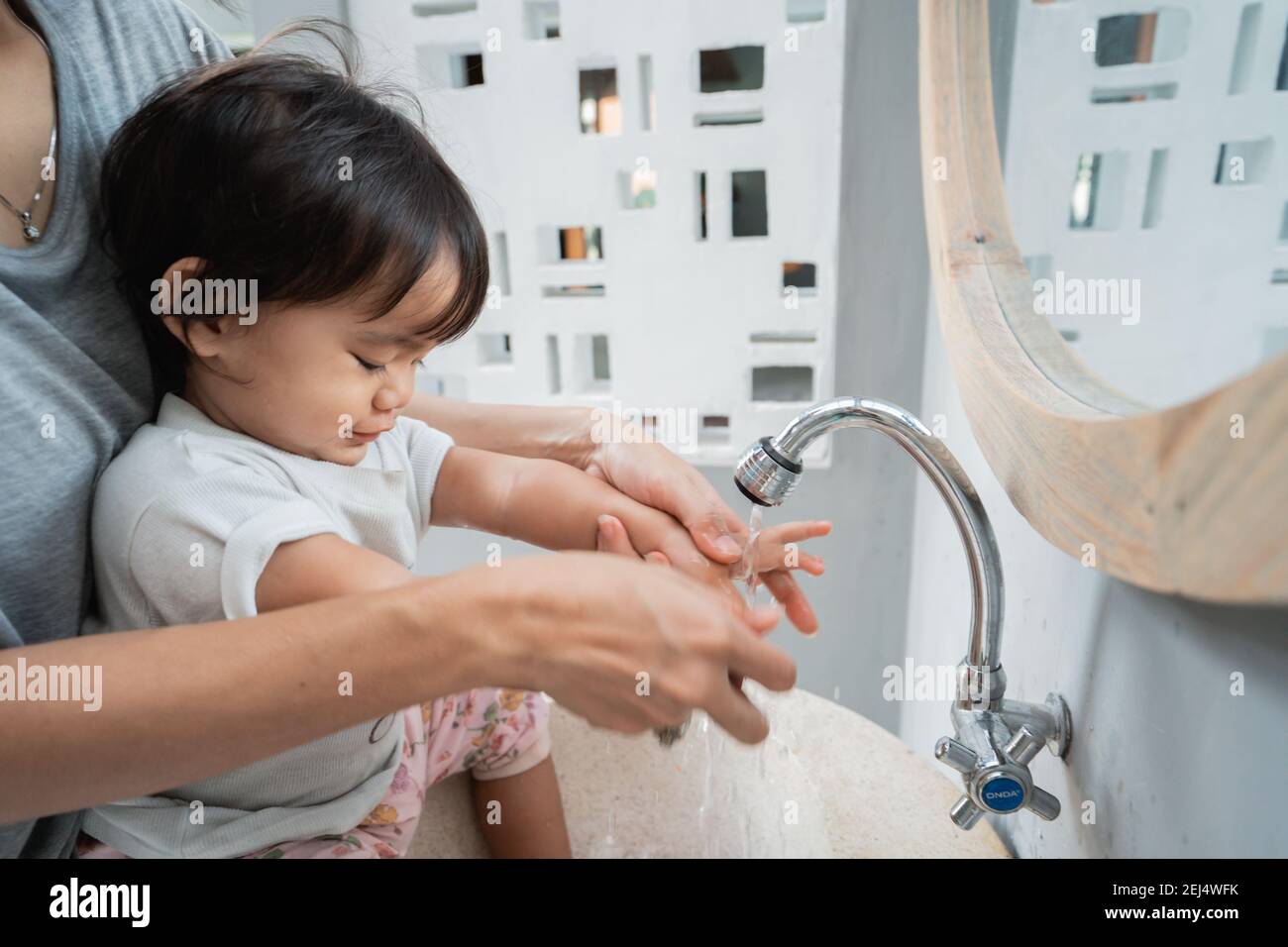 Cute little Asian toddler baby child washing cleaning hands with mom on ...