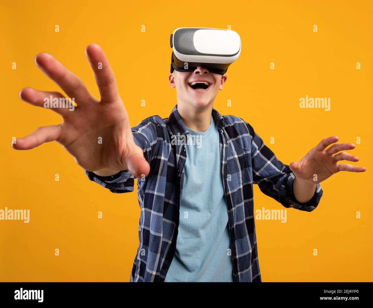 Excited young guy experiencing virtual reality in VR headset, making ...