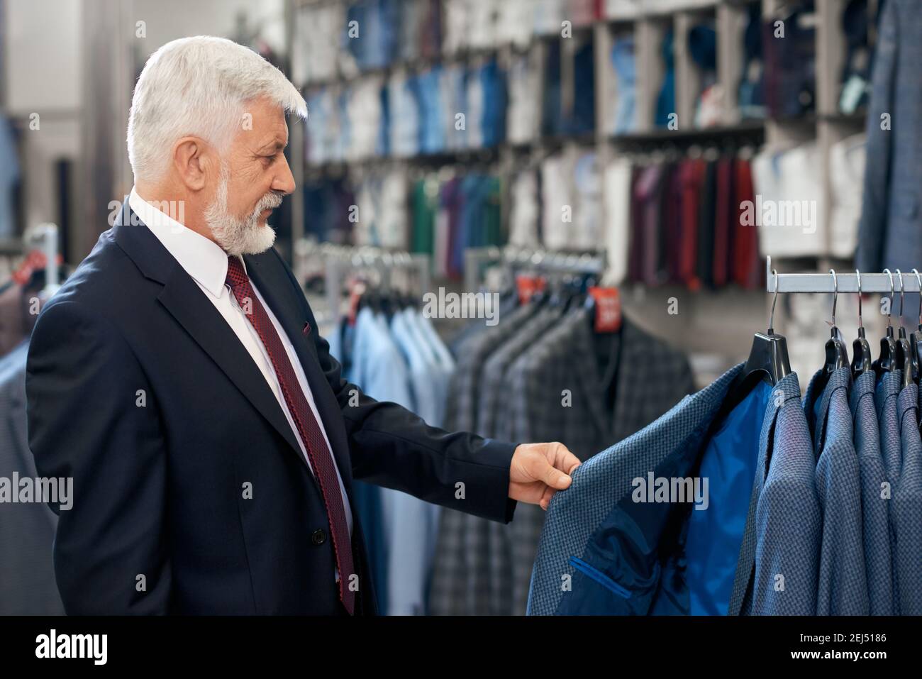 Side view of older elegant client in black costume with grey beard ...