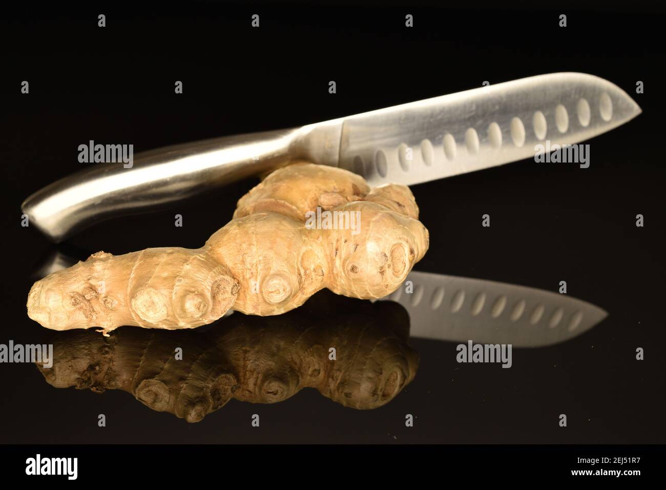 One fresh spicy fragrant organic ginger root on a black background ...