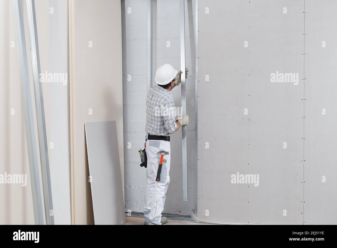 man worker with drywall metal profiles for installing plasterboard ...