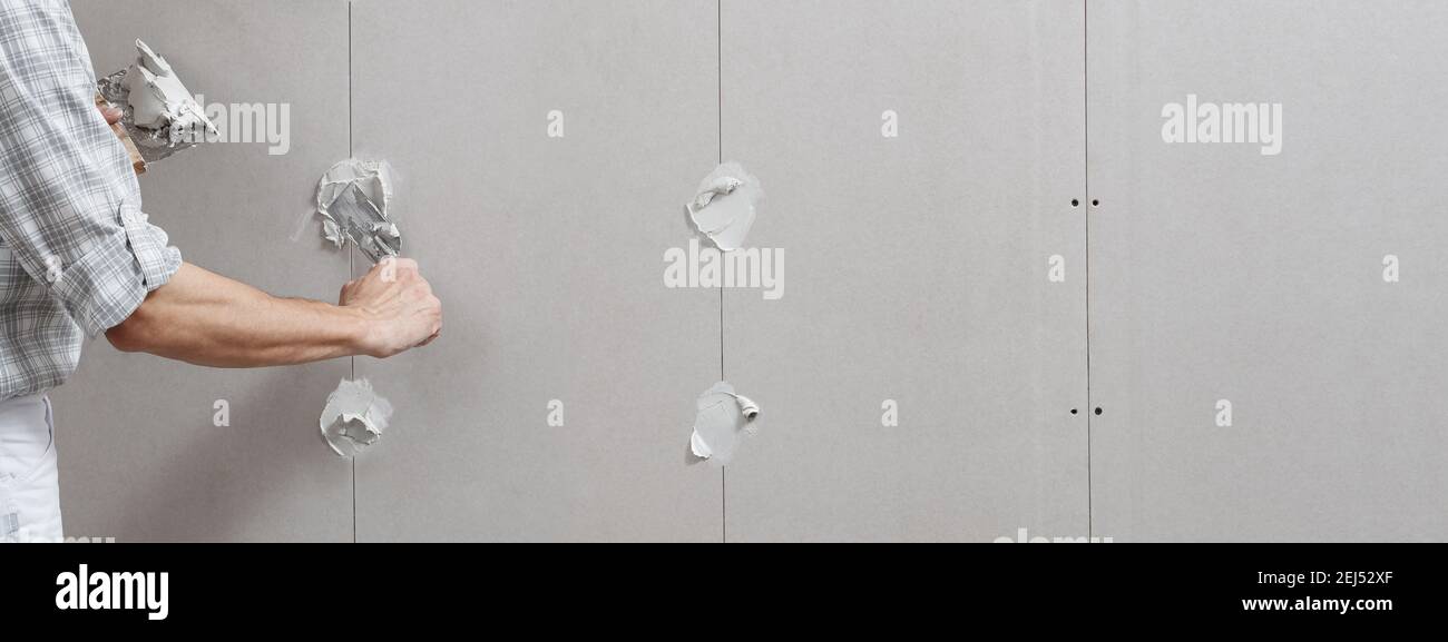 closeup hands man drywall worker or plasterer putting stucco on ...