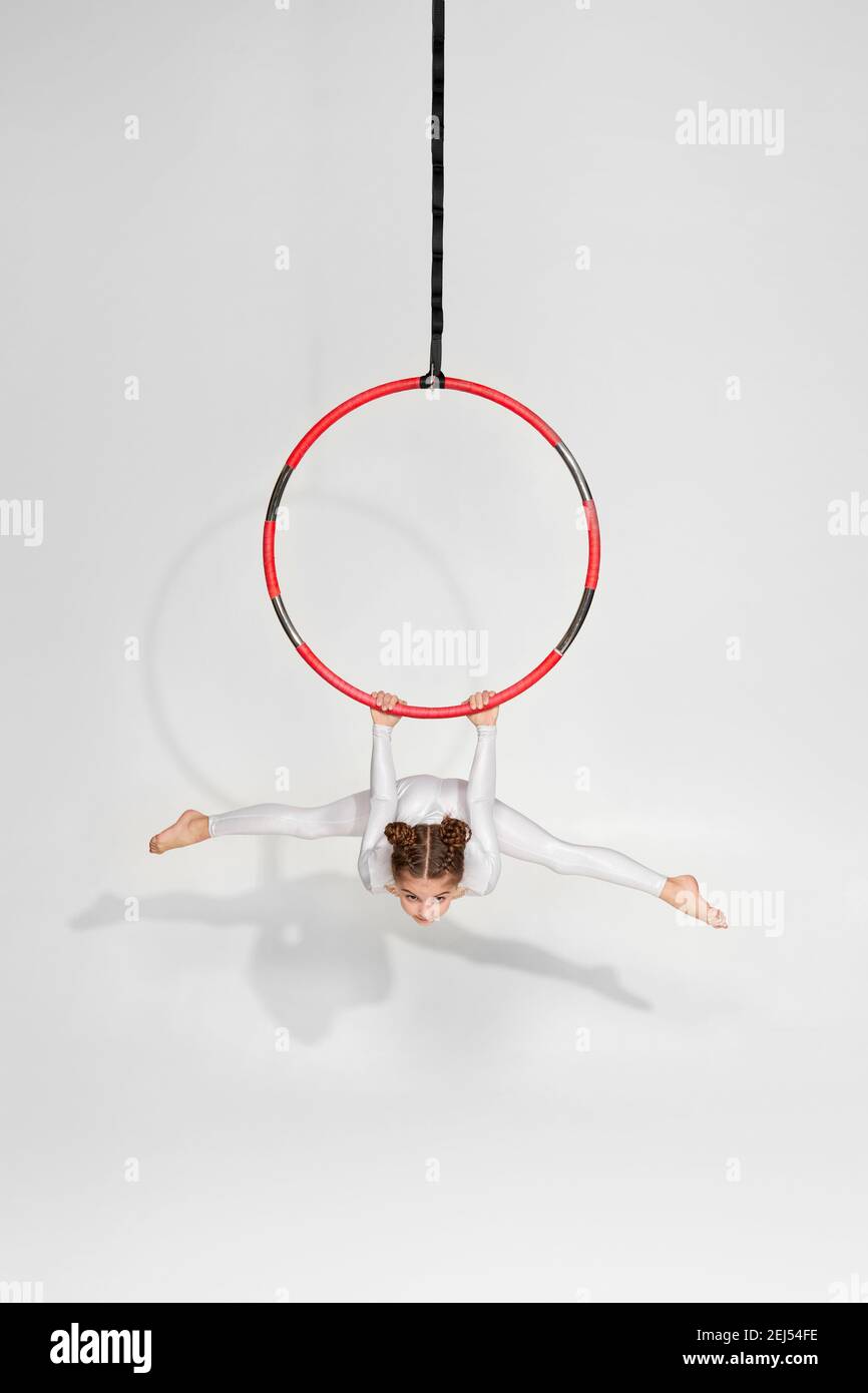 graceful little child girl gymnast in white sportwear doing twine on an ...