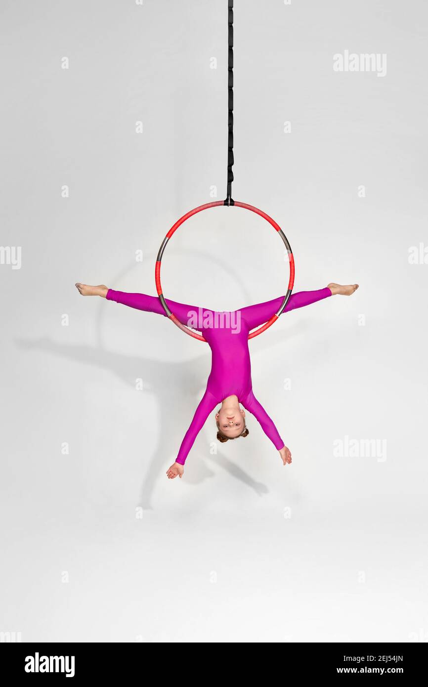 little child girl gymnast in pink sportwear shows an acrobatic ...