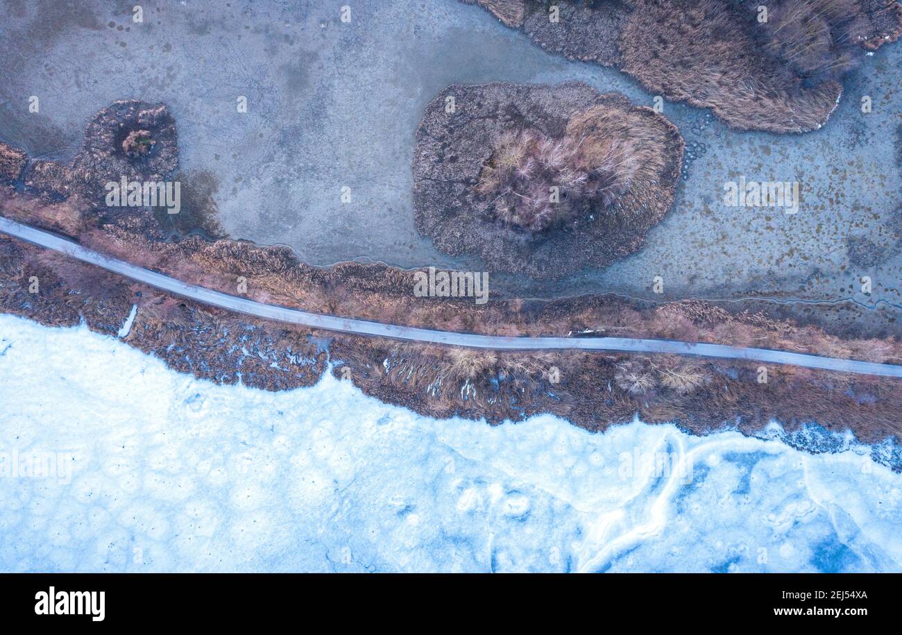 Aerial drone fly air shot, view on ice lake frozen winter top down road ...