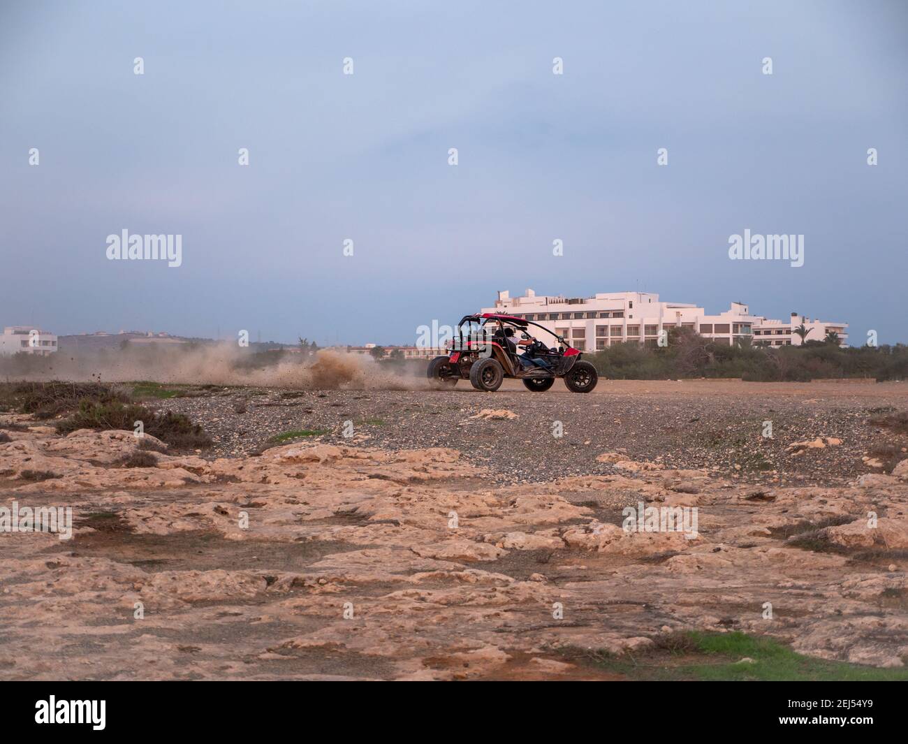 High-speed fast off-road buggy cars racing at waste land with big rocks ...