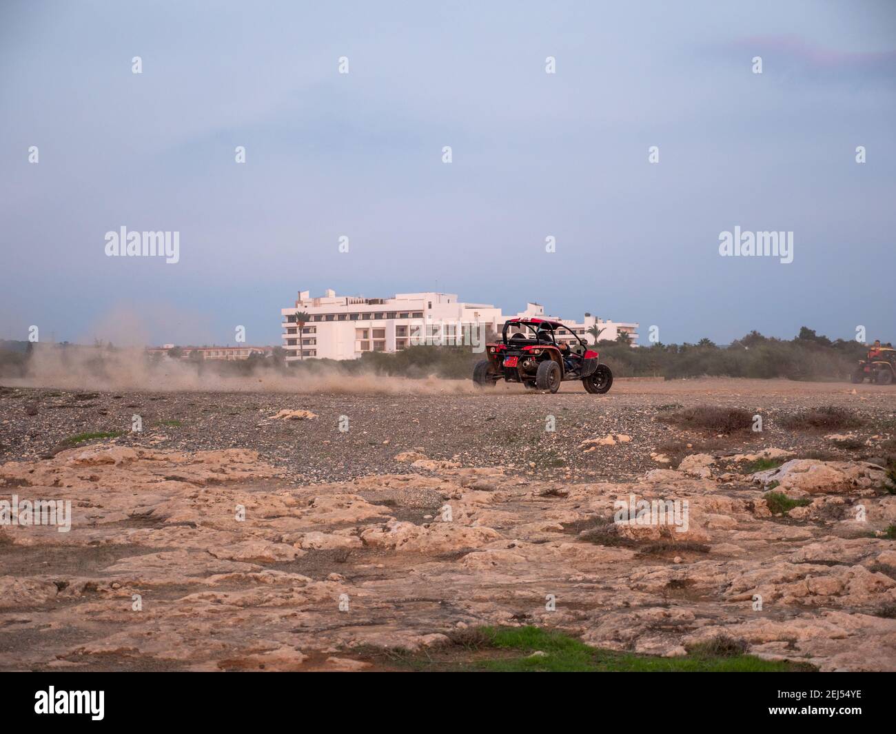 High-speed fast off-road buggy cars racing at waste land with big rocks ...