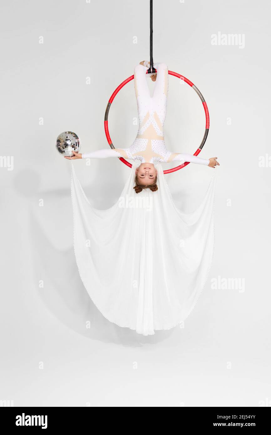 Little acrobat girl shows an acrobatic performance with mirror ball on ...