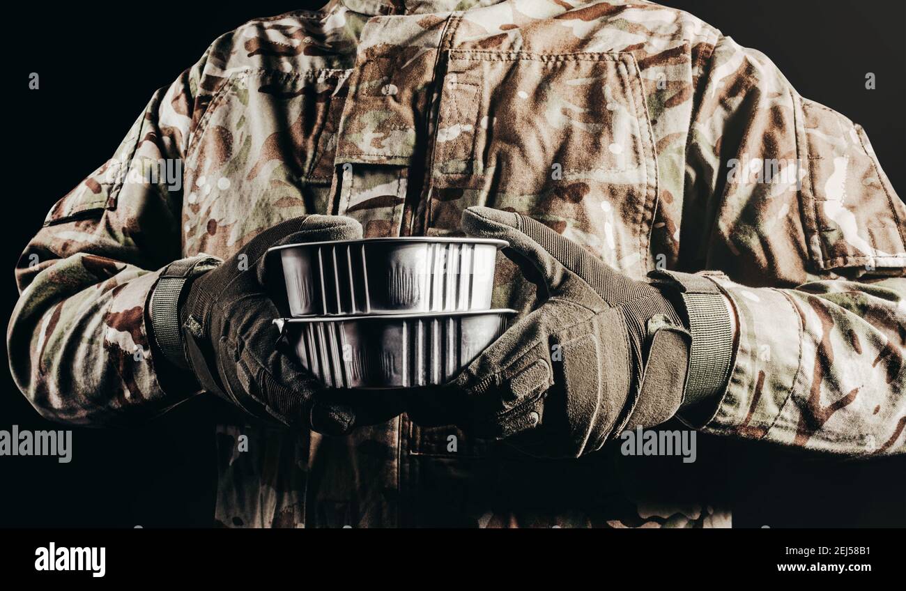 Photo of soldier in camouflaged uniform and tactical gloves holding ...
