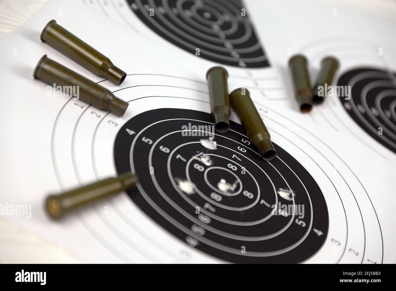 Many bullets with shooting targets on white table in shooting range ...