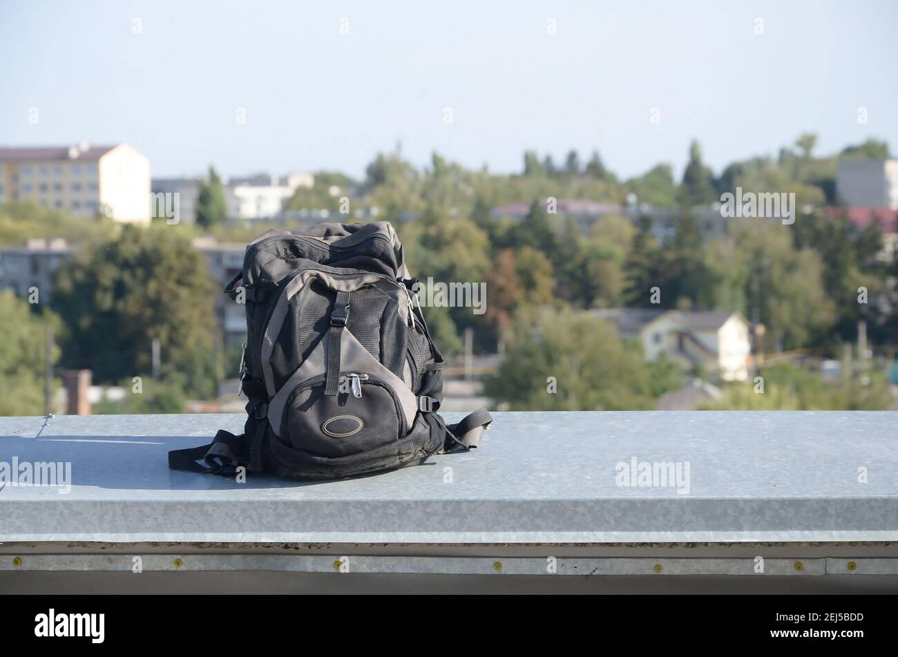 Black backpack lies on metal border of residental multistorey building ...