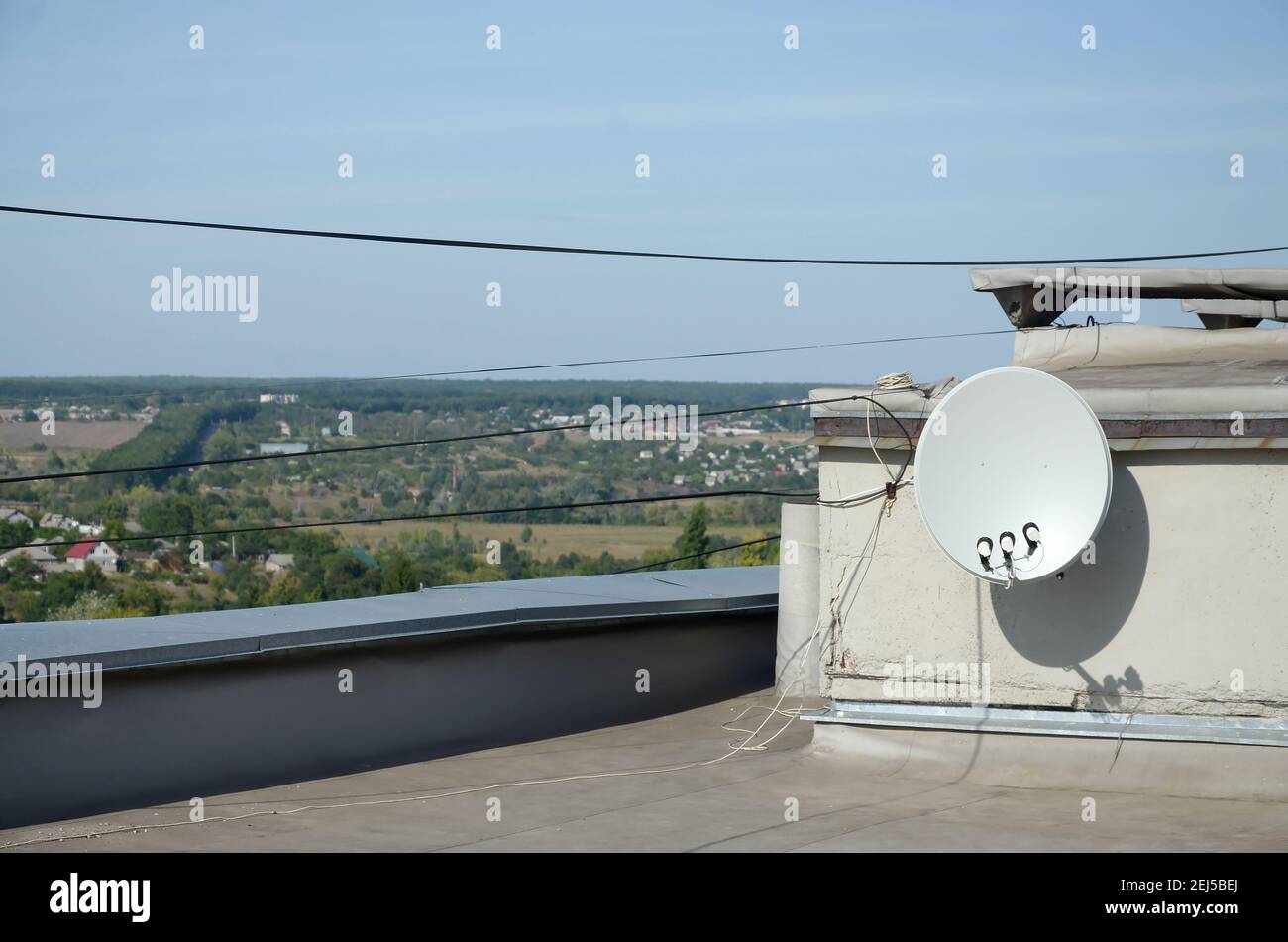 White satellite dish with three converters mounted on residental ...