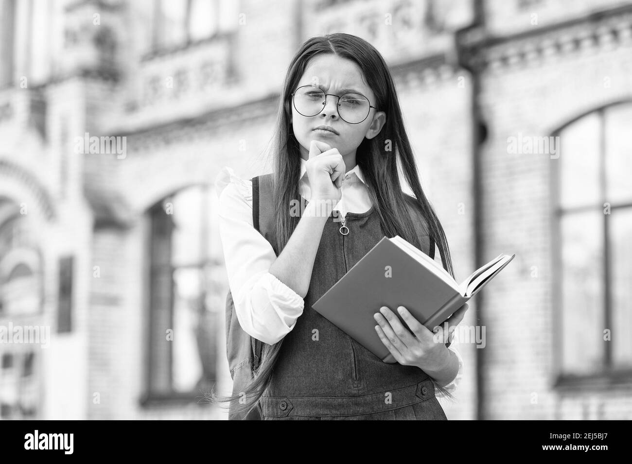 Imagine your dreams. Little kid hold book with thoughtful look ...