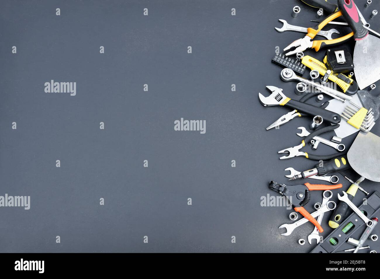 Handyman tool kit on black wooden table. Many wrenches and screwdrivers ...