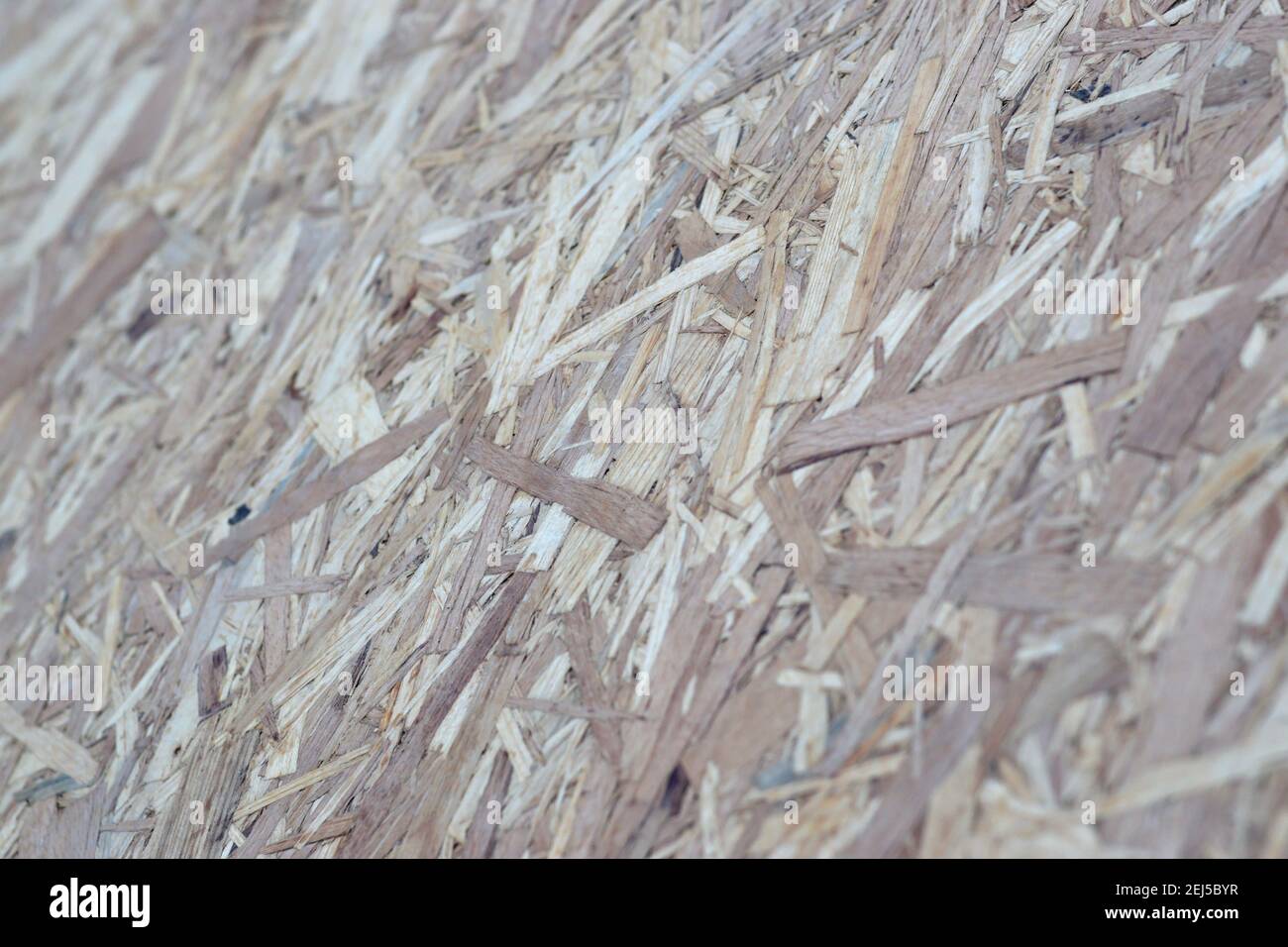 OSB boards made of brown wood chips sanded into a wooden background ...