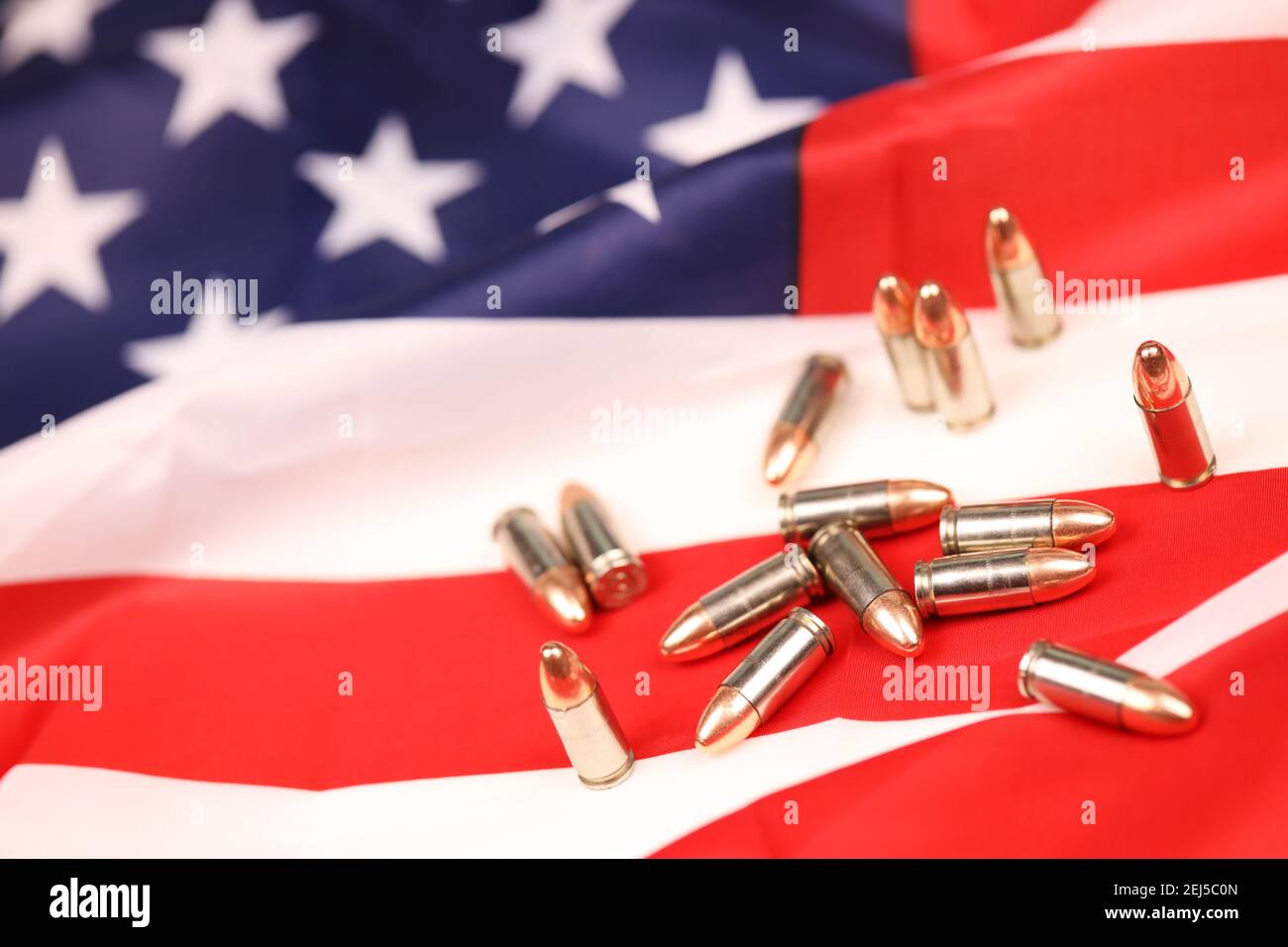 Many yellow 9mm bullets and cartridges on United States flag. Concept ...