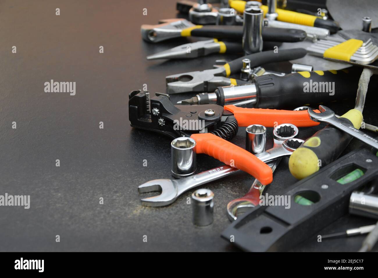 Handyman tool kit on black wooden table. Many wrenches and screwdrivers ...