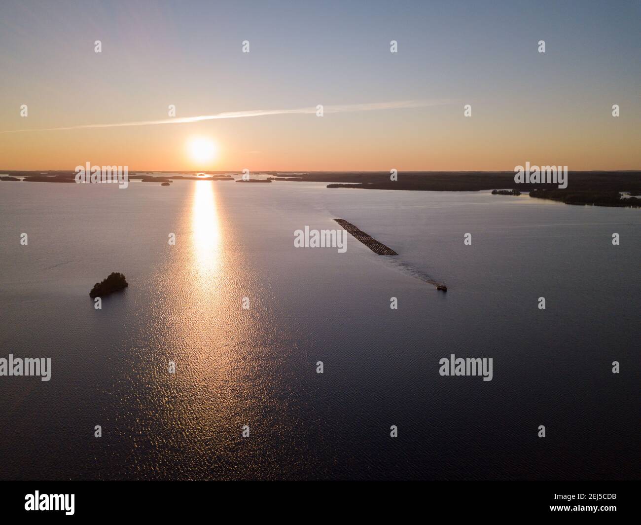 Timber rafting at lake during sunset Stock Photo - Alamy