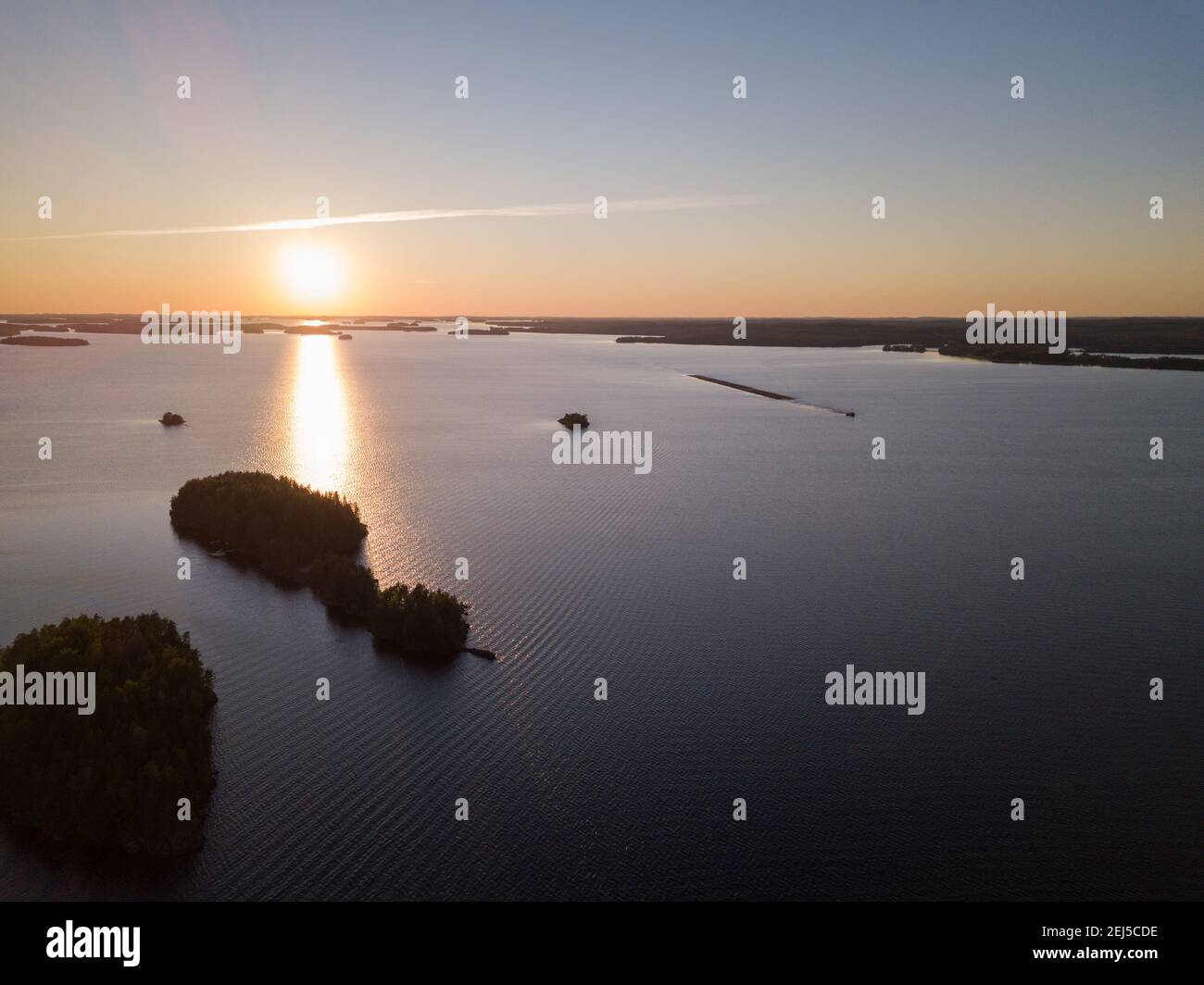 Timber rafting at lake during sunset Stock Photo - Alamy