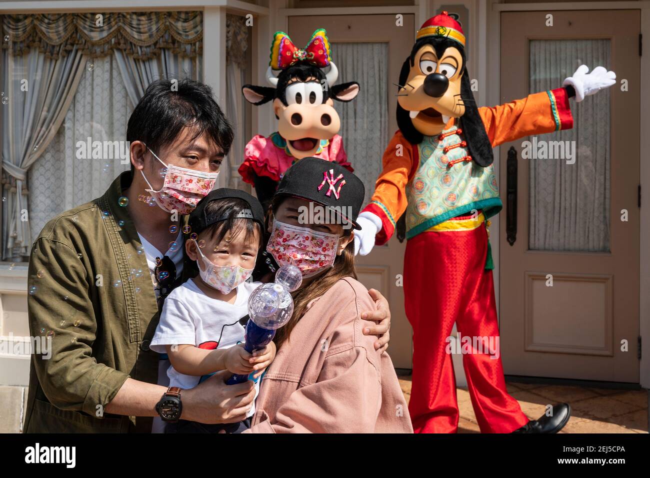 Visitors pose for a picture with Disney characters Goofy and Clarabelle ...
