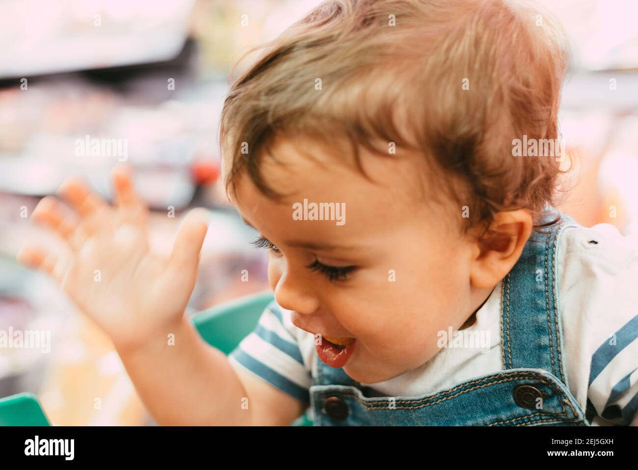 close-up of 18-month-old child in supermarket with unfocused background ...