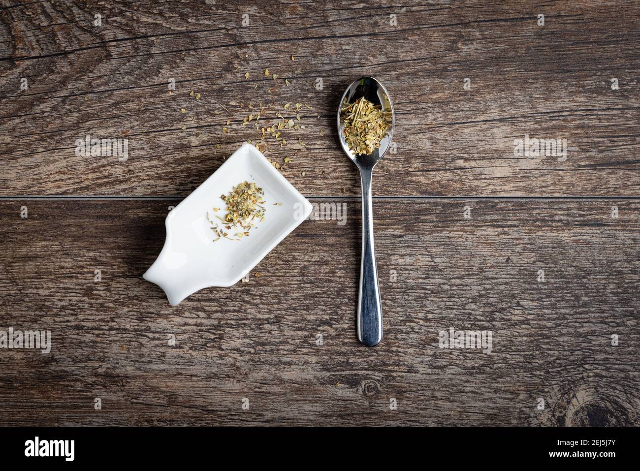 Metal spoon with seasoning dish on a wood floor Stock Photo - Alamy