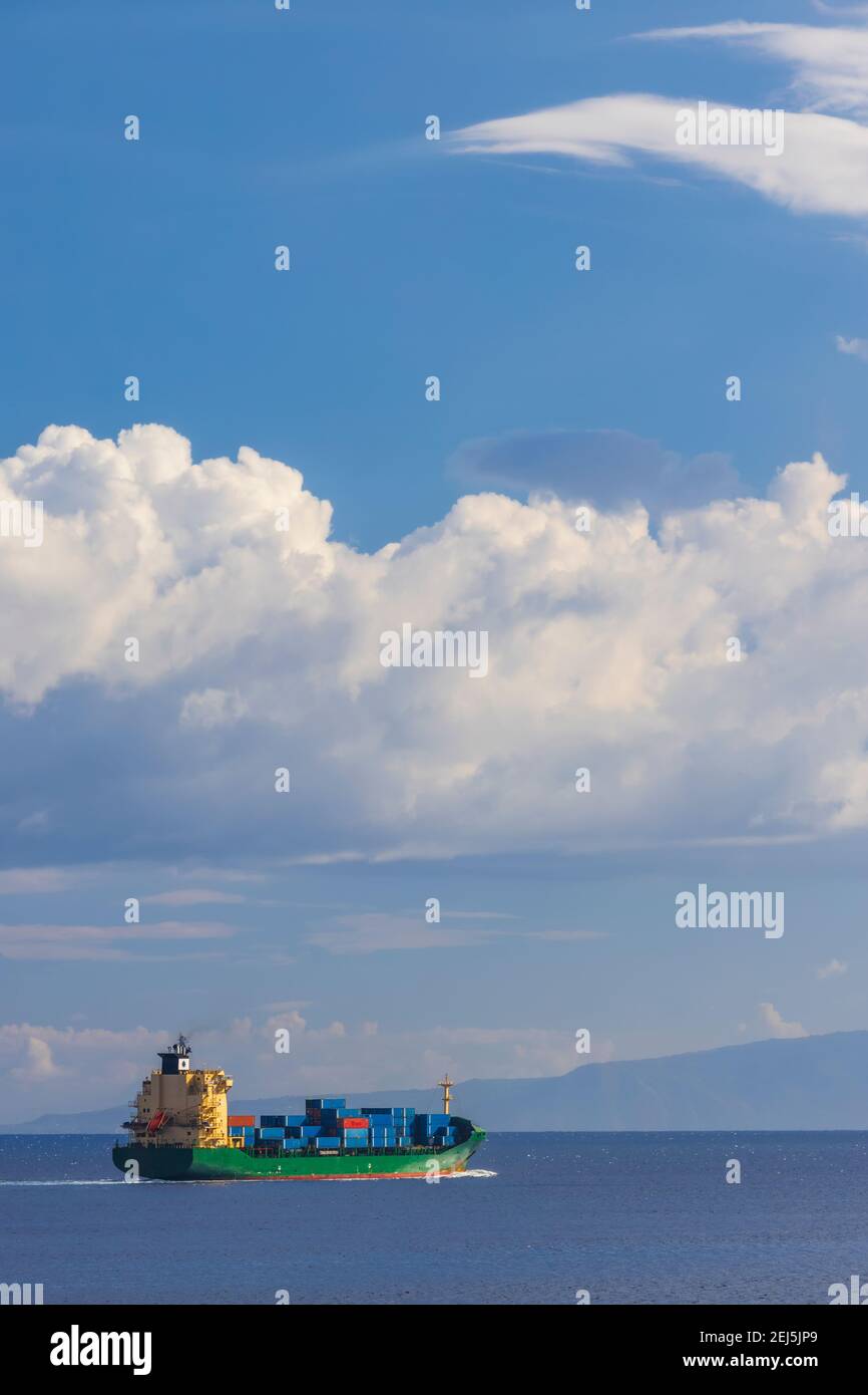 cargo ship nearby Capo Peloro Lighthouse in Punta del Faro on the ...