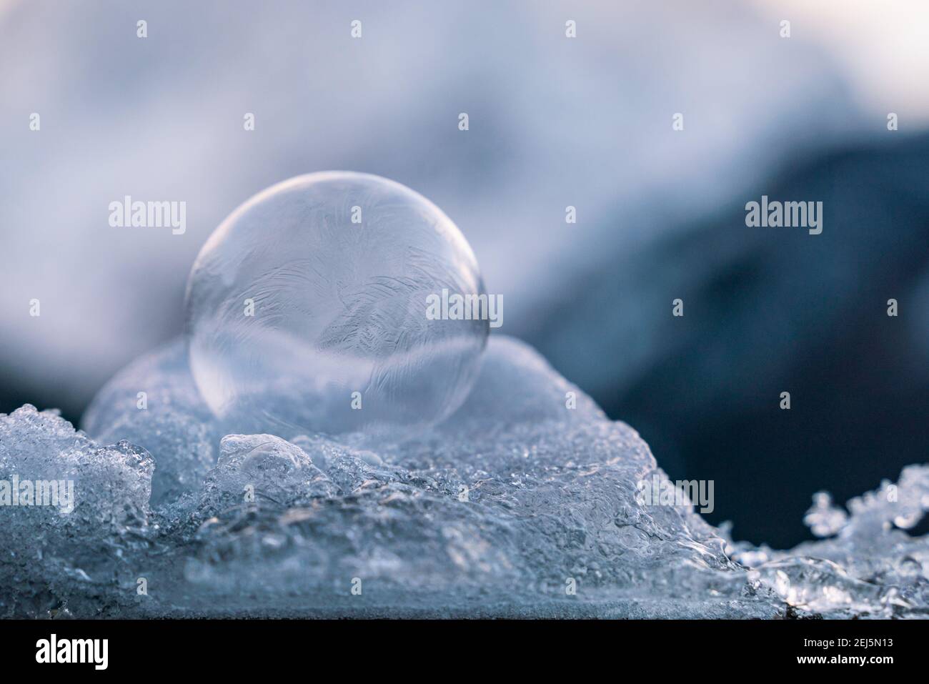 Beautiful frozen bubbles sitting on a pile of snow and ice with a ...