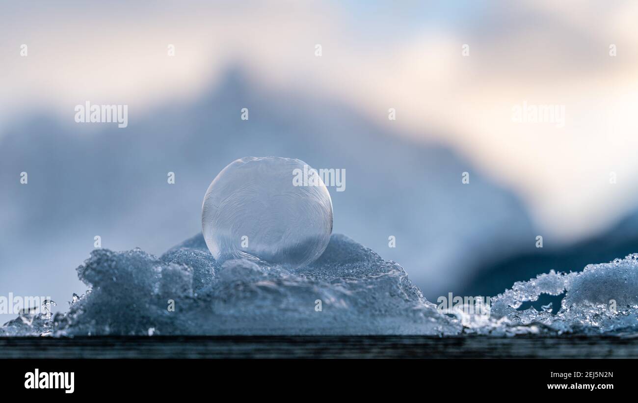 Beautiful frozen bubbles sitting on a pile of snow and ice with a ...