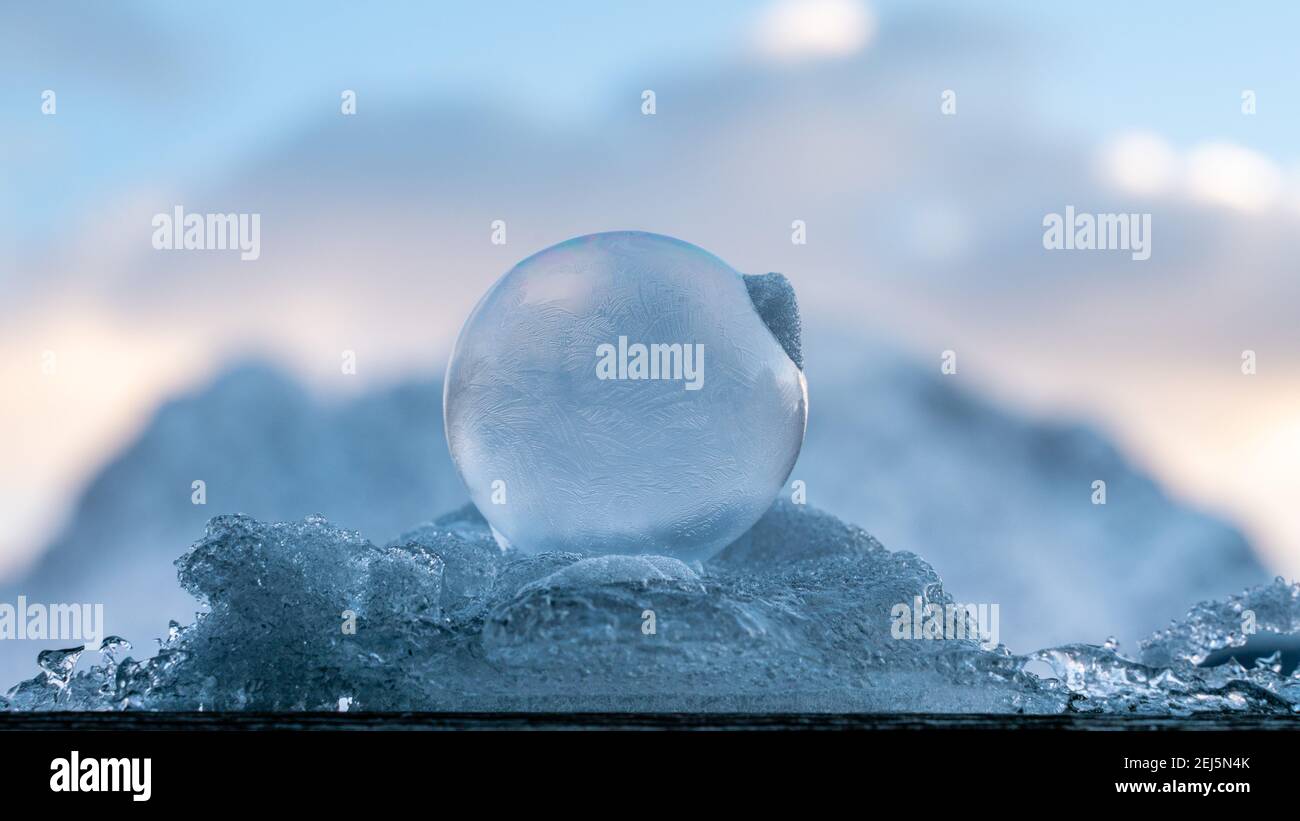 Beautiful frozen bubbles sitting on a pile of snow and ice with a ...