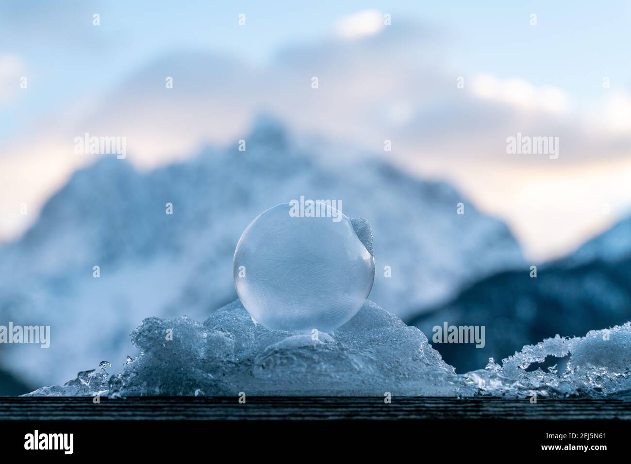 Beautiful frozen bubbles sitting on a pile of snow and ice with a ...