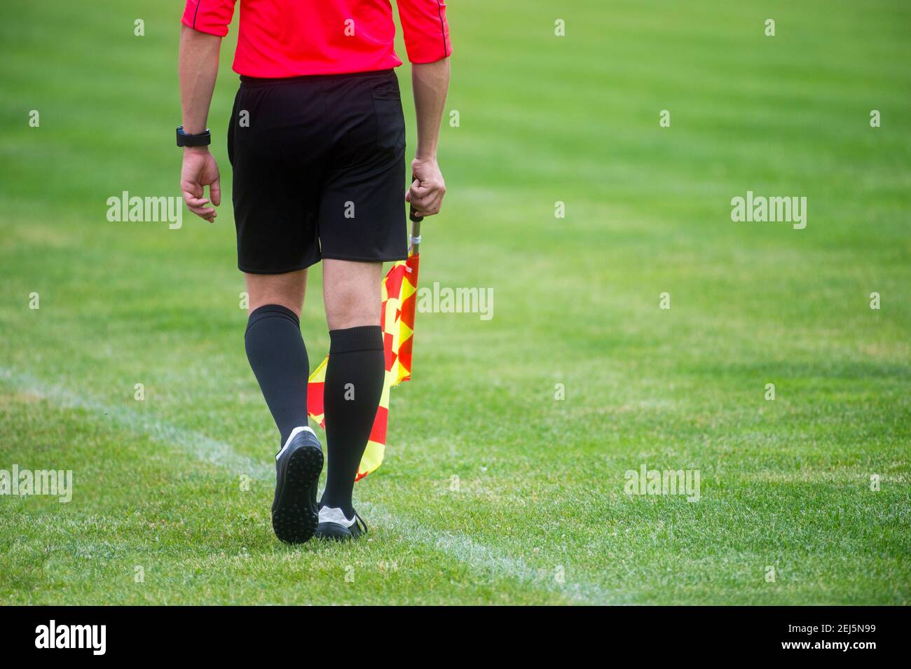 Low Section Of Referee With Flag Walking On Soccer Field Stock Photo ...