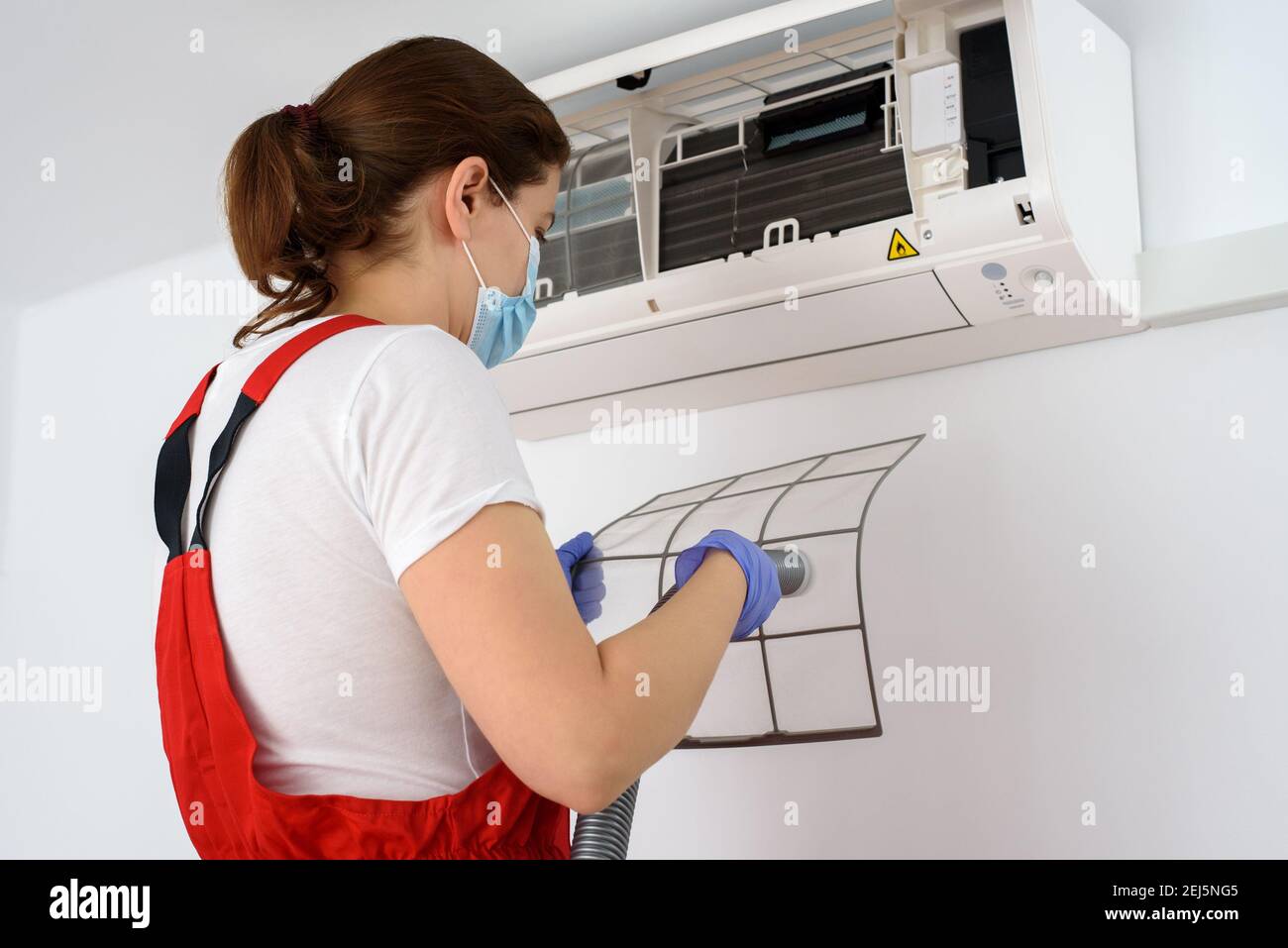 Female technician wearing face mask and cleaning air conditioner Stock ...