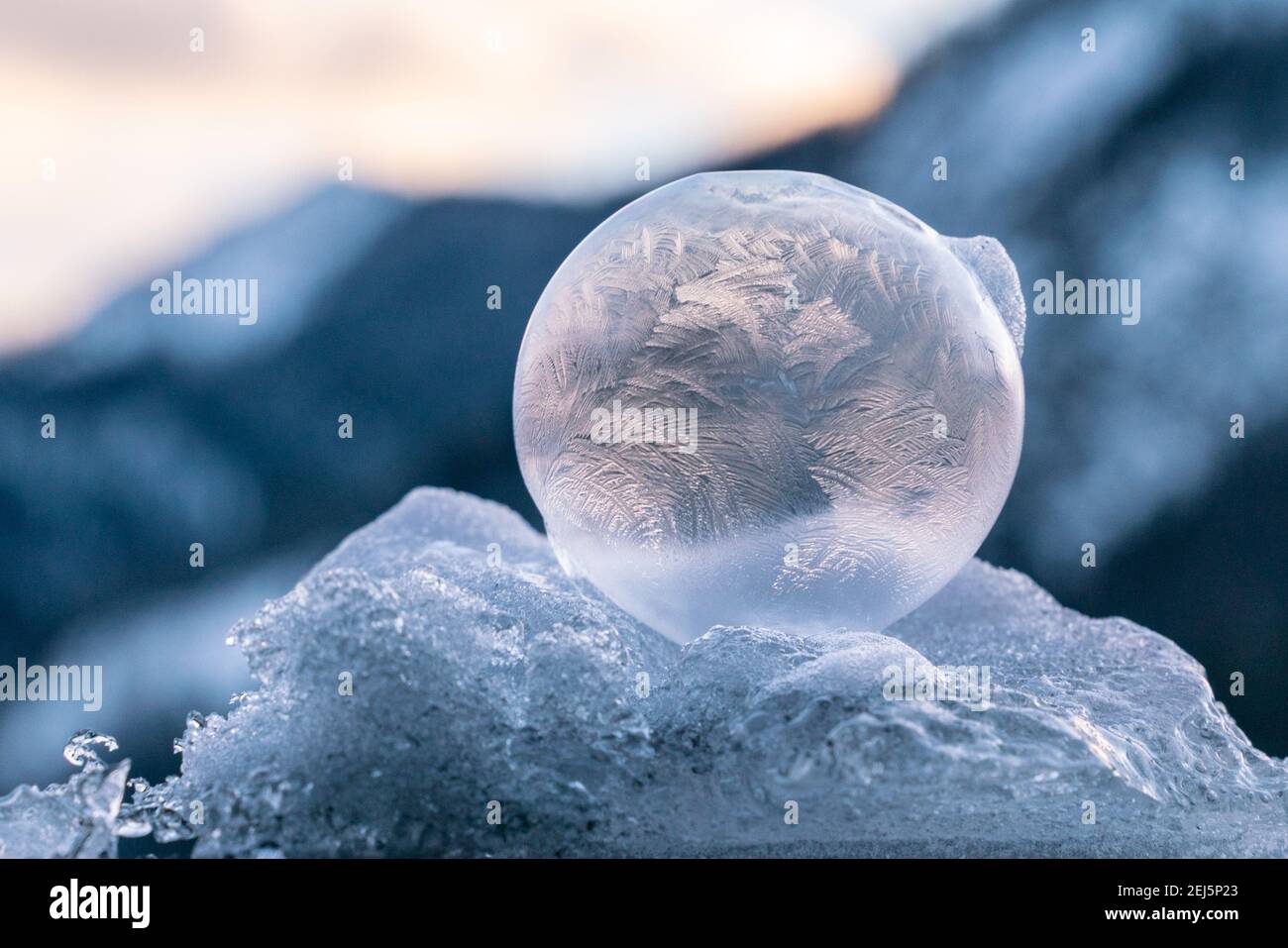 Beautiful frozen bubbles sitting on a pile of snow and ice with a ...
