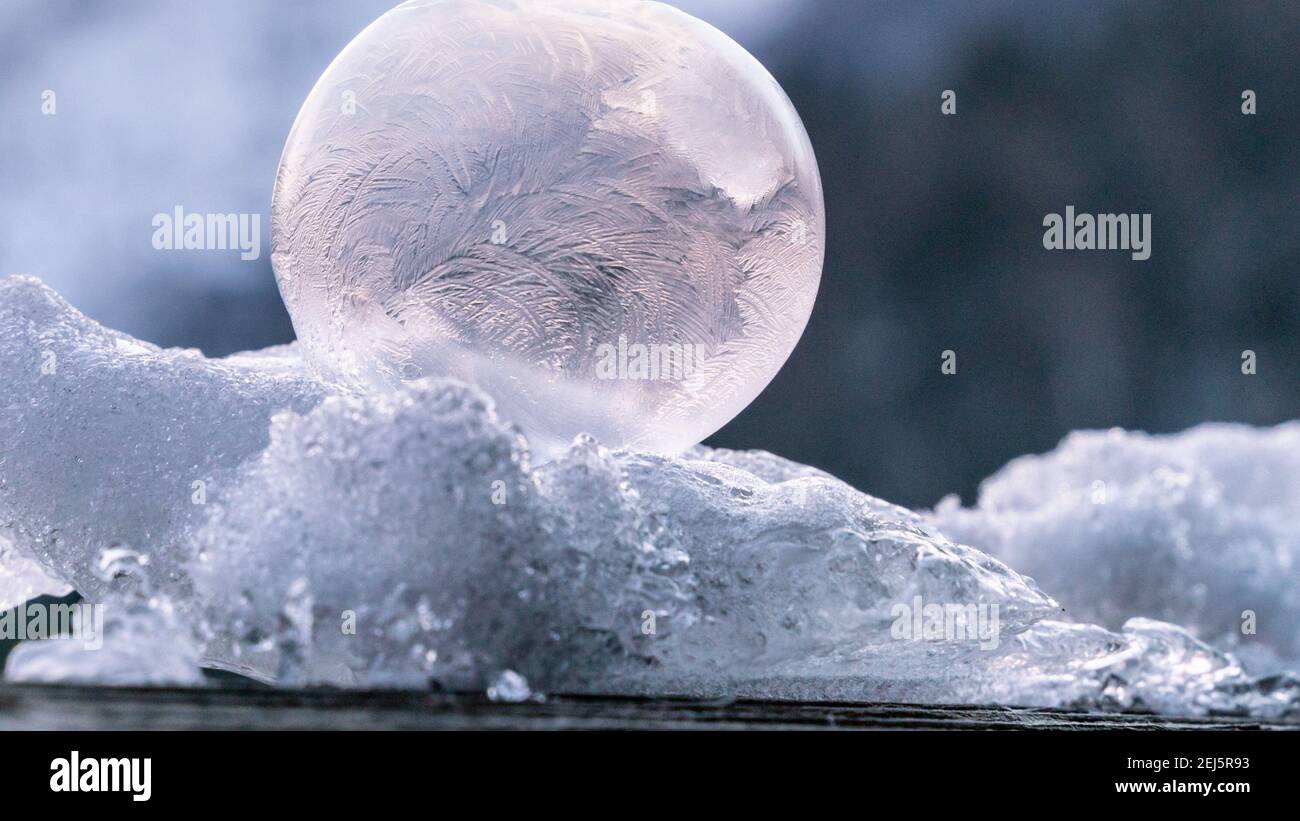 Beautiful frozen bubbles sitting on a pile of snow and ice with a ...
