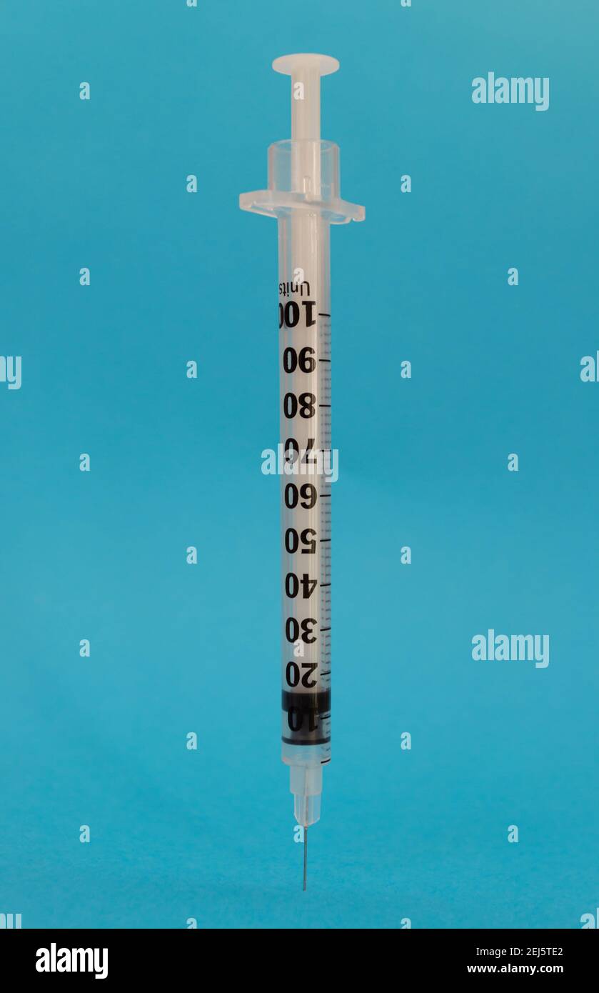 Insulin syringe vertically on a blue background. The concept of health ...