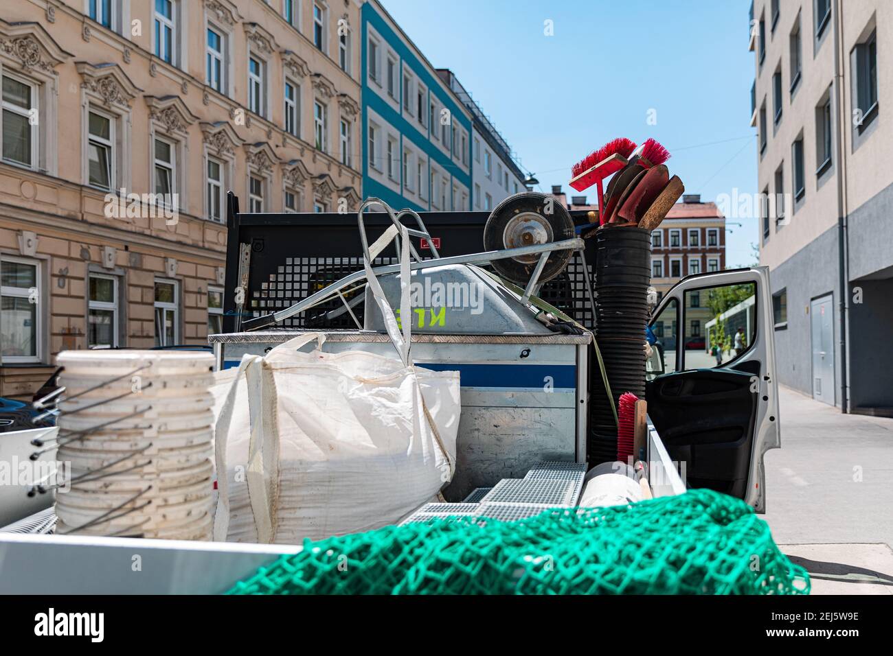tools lie in the trunk of car, auto parked between two low buildings ...