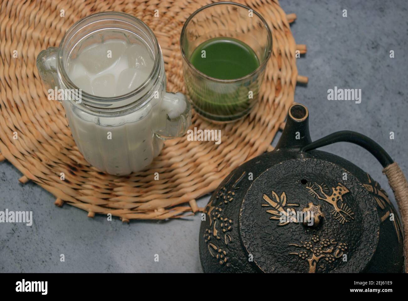 Horizontal image iced milk glass ant green tea liquid and teapot on ...