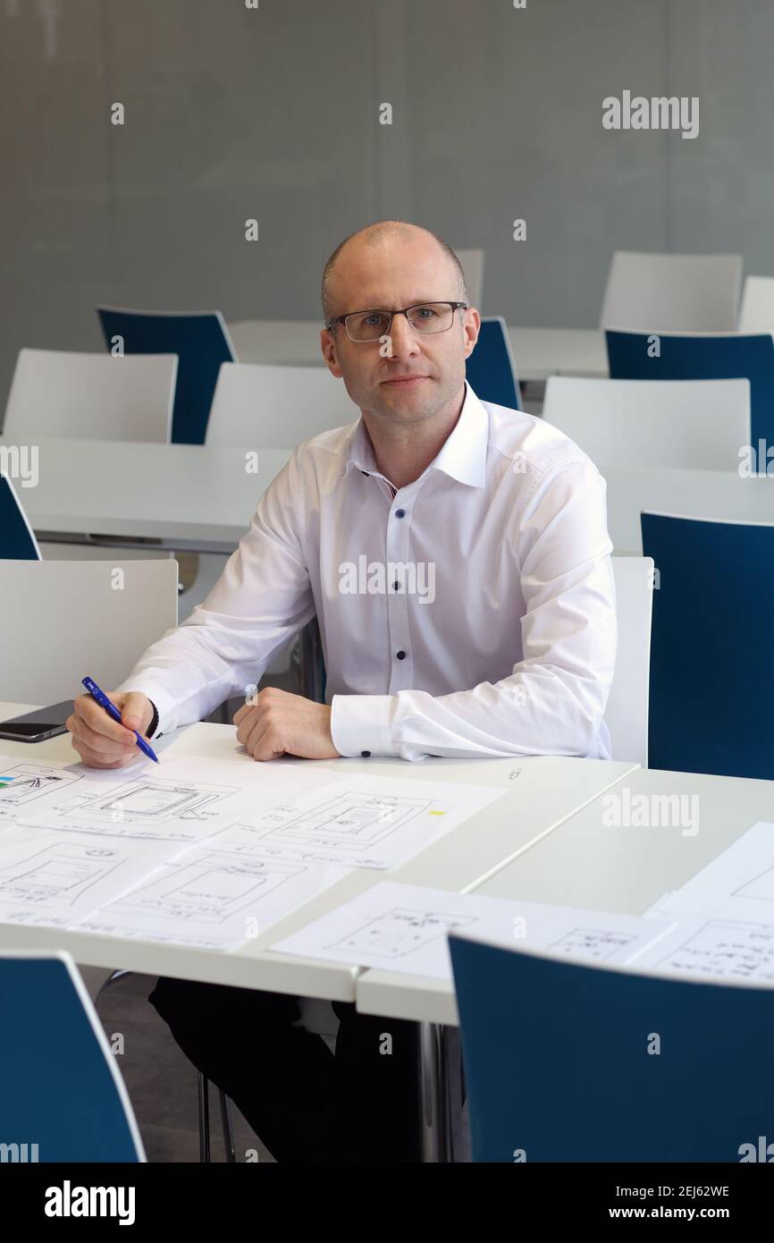 Businessman reviewing paperwork in conference room Stock Photo - Alamy