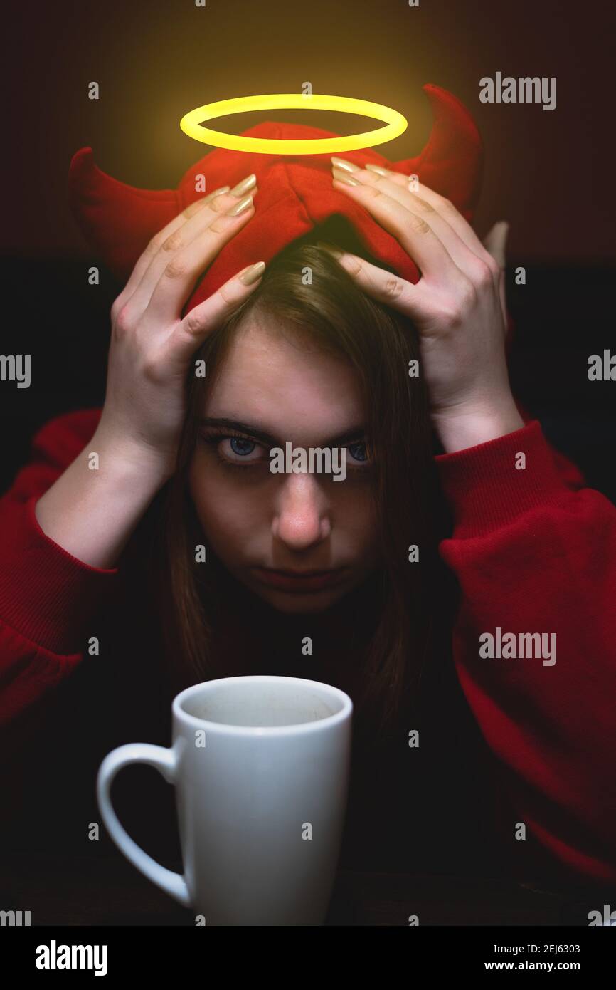 A young girl with devil horns and angel nimbus over the head, the ...