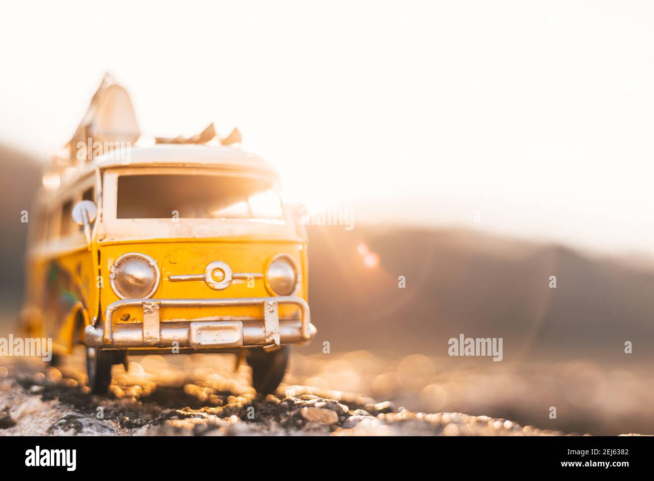 Small hippie yellow van toy on the road. Vacation, traveling concept ...