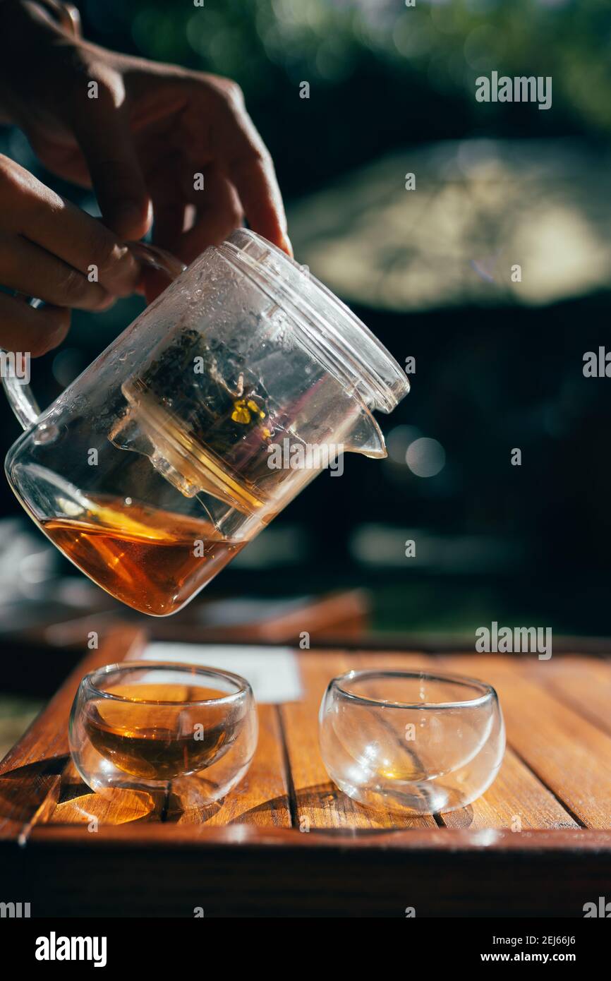 Pouring black tea, female hand holding a teapot Stock Photo - Alamy