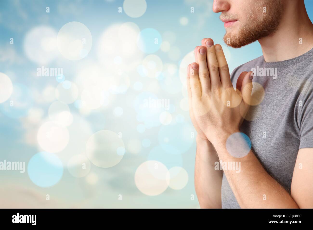 Religious young man praying to God on color background Stock Photo - Alamy