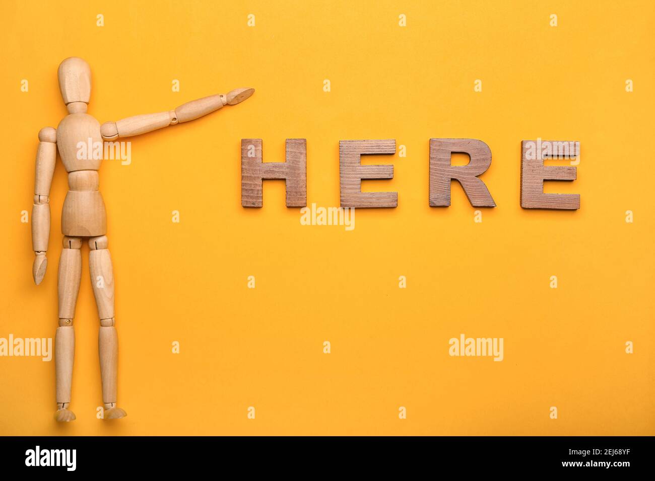 Wooden mannequin with word HERE on color background Stock Photo - Alamy